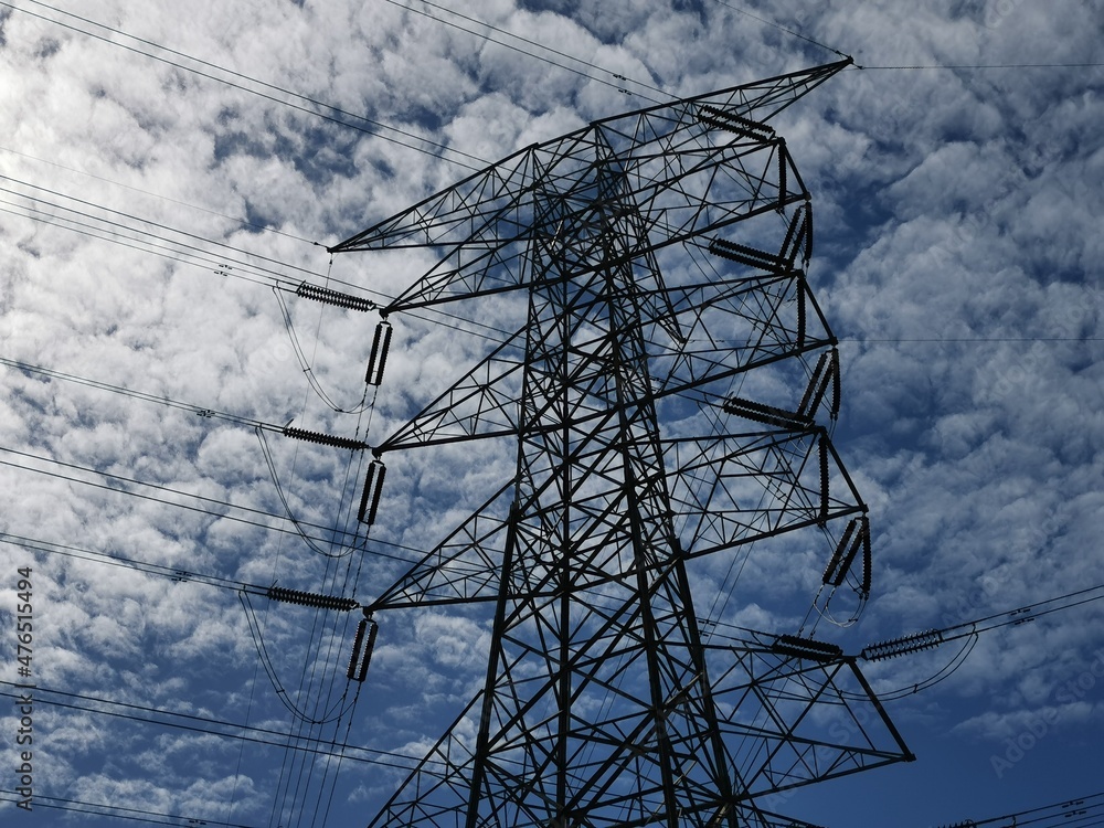 High voltage transmission tower against blue sky with clouds. Stock ...