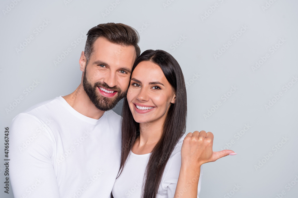 Portrait of attractive cheerful couple cuddling demonstrating copy ...