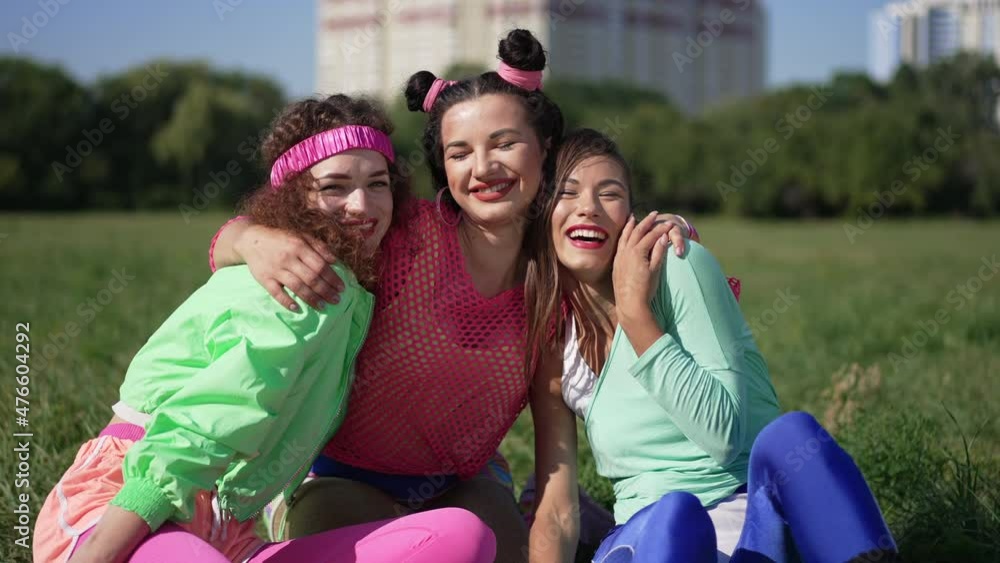 Portrait of three happy friendly retro women hugging looking at camera ...