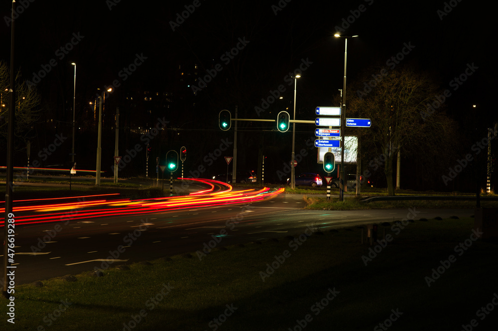Intersection at night with traffic lights and traffic blurred by motion ...
