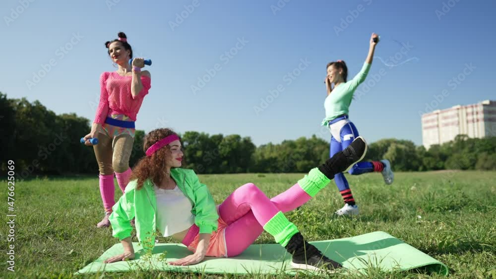 Self confident retro sportswoman lying on exercise mat raising one leg ...