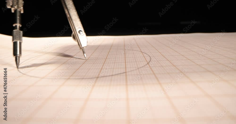 Macro of the compass drawing a circle on paper. Close up, side-view ...