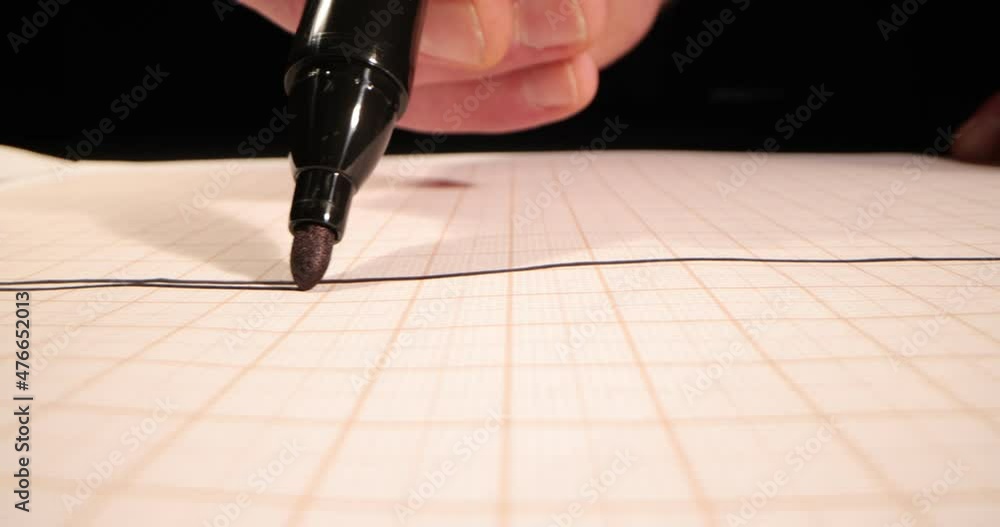 A close-up felt-tip pen drawing black sinuous lines. Artist hand ...