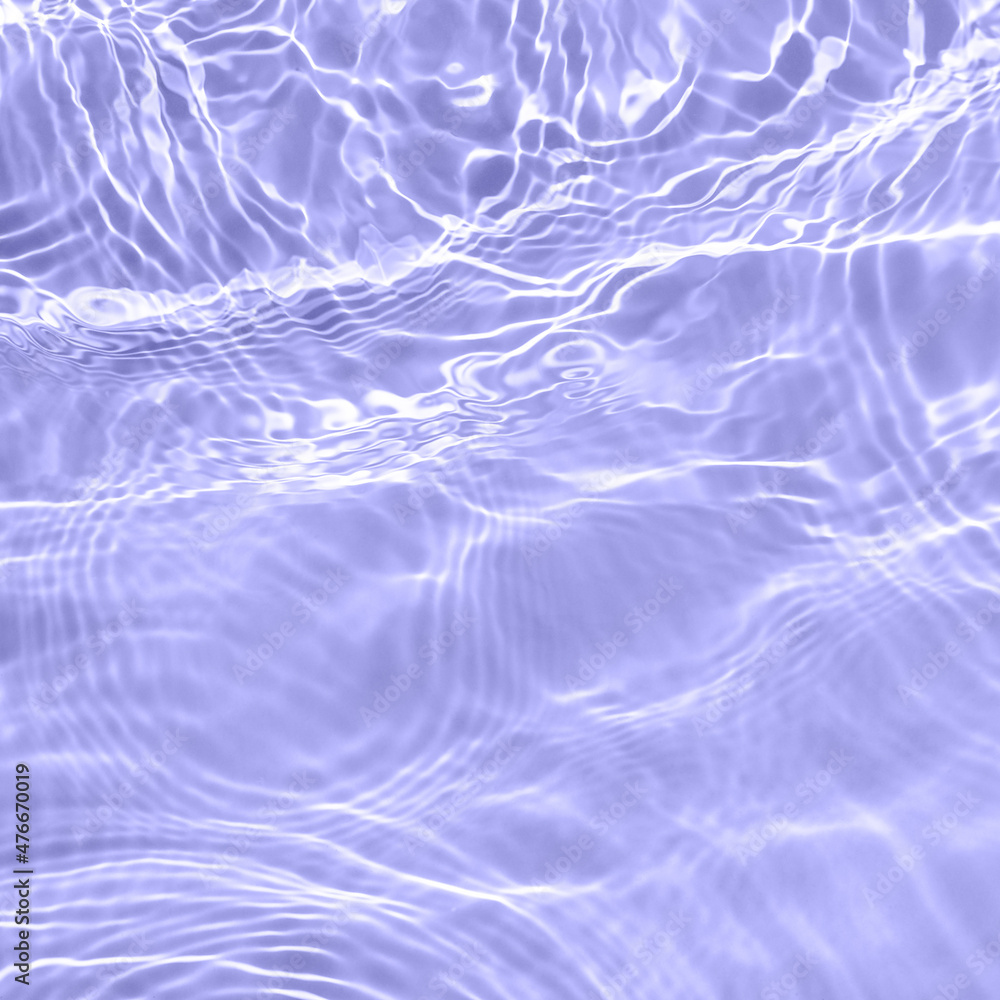 The surface of light on the purple transparent swimming pool water ...