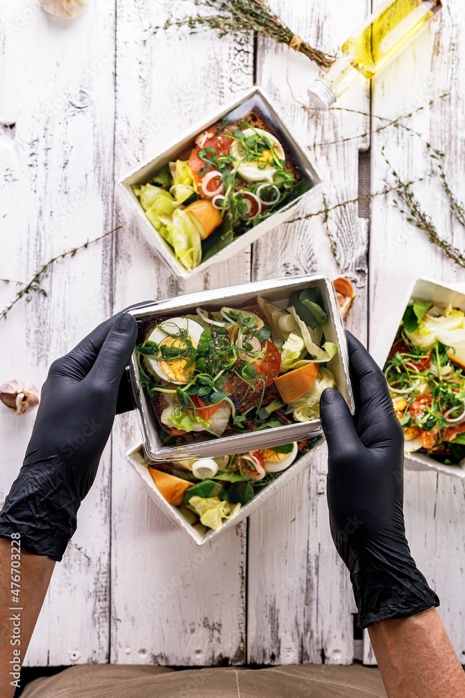 Foto de Hands in black gloves are packing a business lunch in a ...