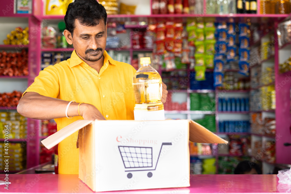 Grocery or kirana store shopkeeper packing groceries on e-commerce ...