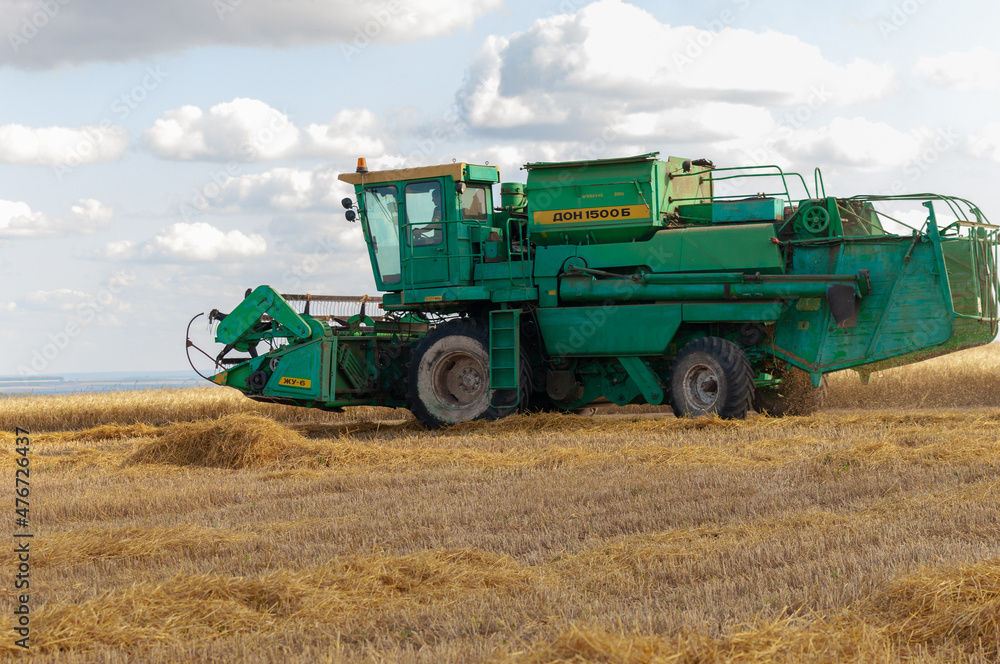 Summer photo of barley harvesting, “Combine Harvester” is a mechanized ...