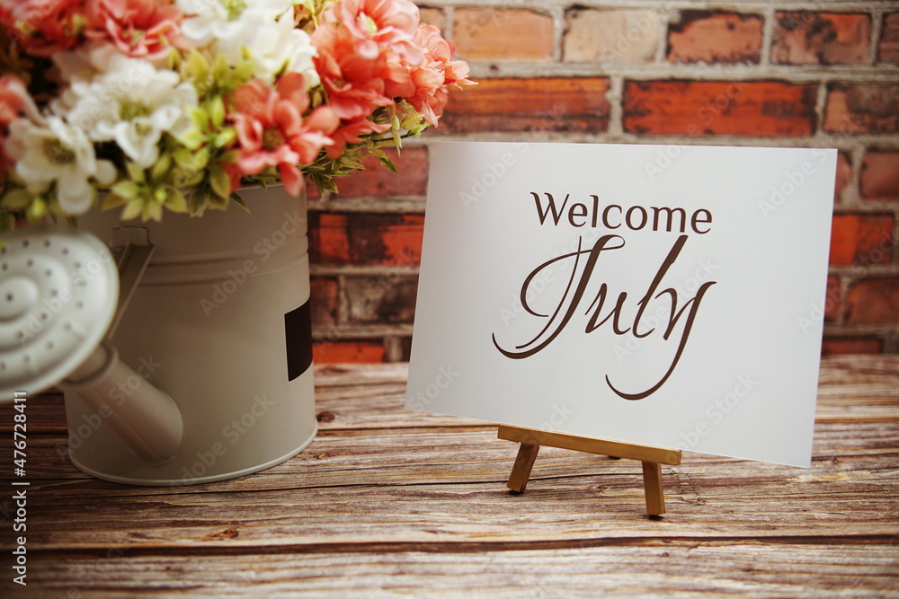 Welcome July text with flower bouquet decoration on wooden and old ...