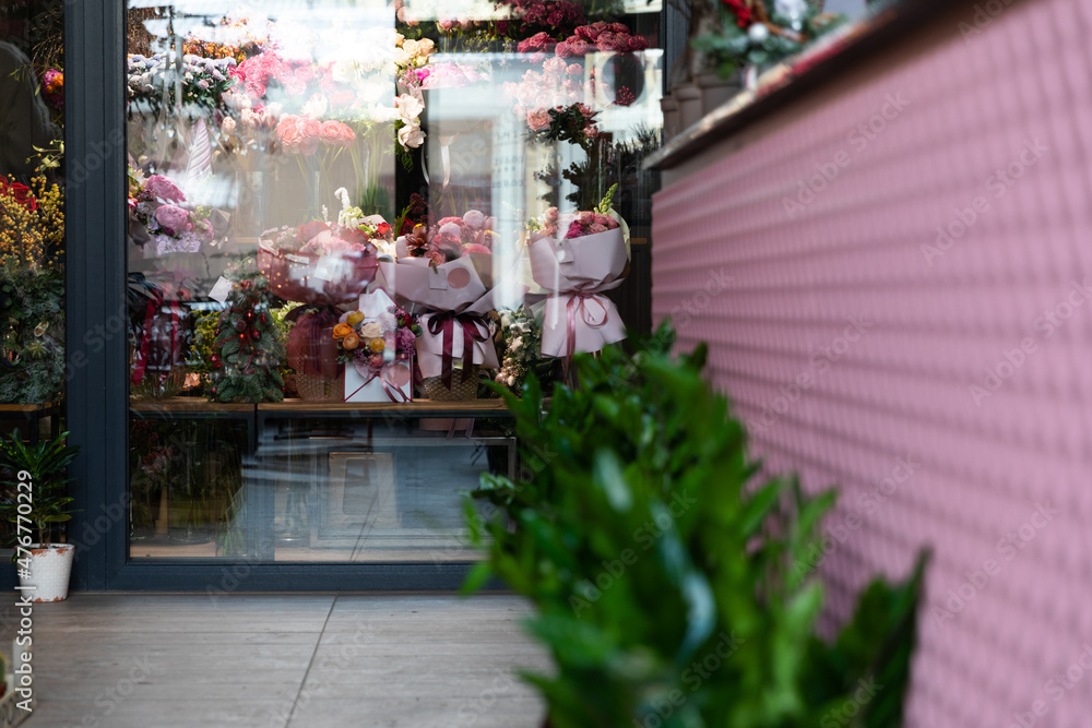 florist shop window with flower arrangements behind glass, photograph ...