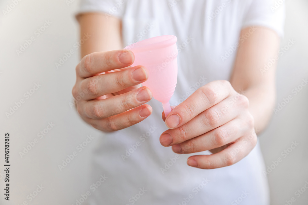 Woman hand holding pink menstrual cup isolated on white background ...