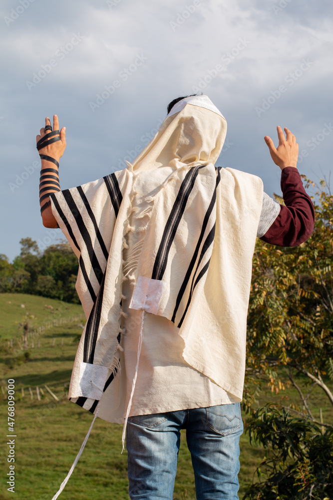 Vertical photo of Juido Latino covering his head wearing talit and ...