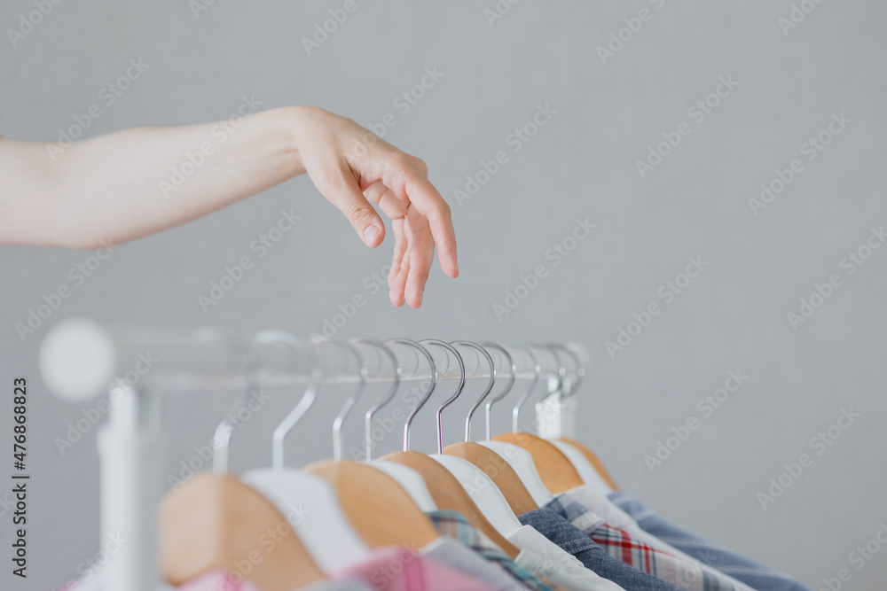 a woman's hand takes a hanger with clothes clothes for a business ...