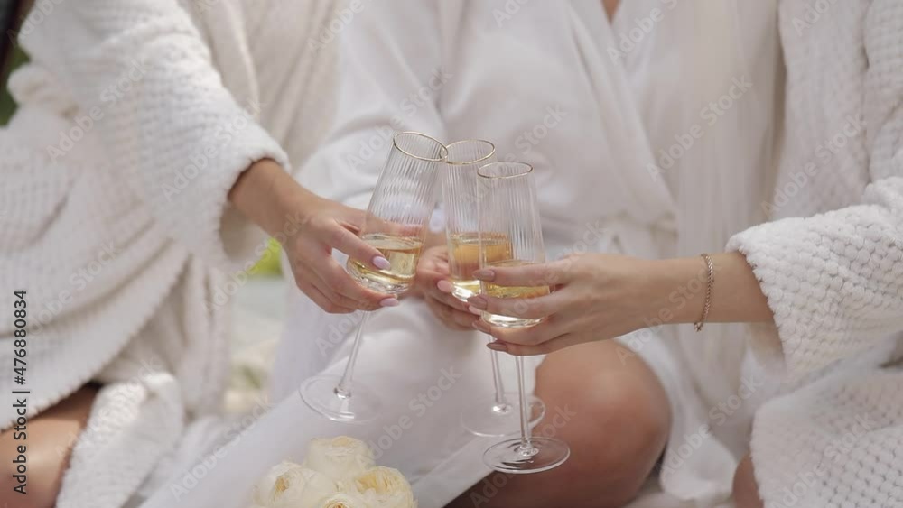 Bride in white boudoir dress sitting, drinking champagne with ...