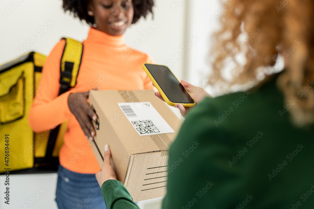 Black woman courier delivering parcel of internet order Stock Photo ...
