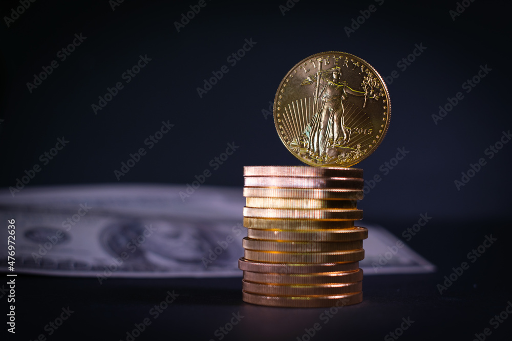 one dollar gold coin stands on a stack of other gold coins Stock Photo ...