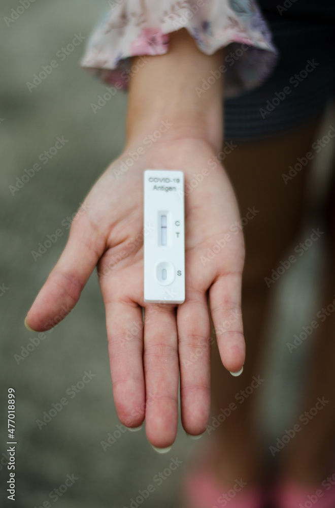 Woman holding Rapid Antigen Test kit with Negative result during swab ...