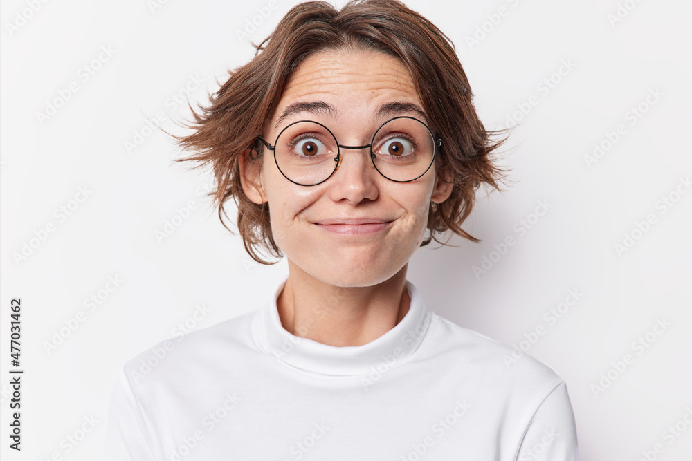Portrait of happy young woman with short hairstye smiles gladfully has ...