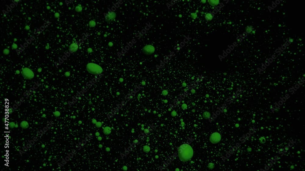 Green volumetric fluorescent particles move and change on a black ...