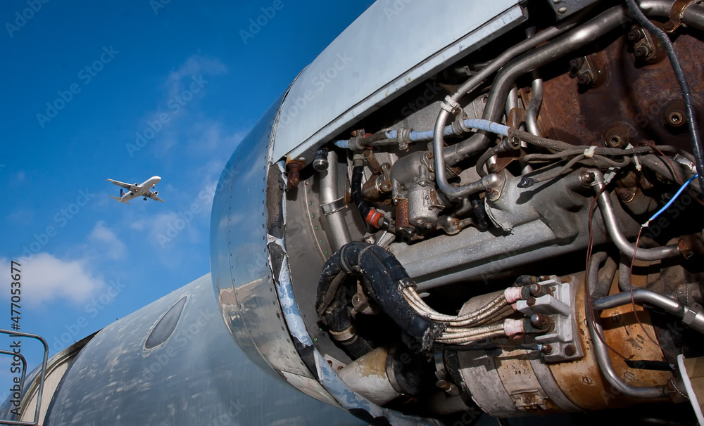 Jet engine exposed with jet flying overhead in the distance Stock Photo ...