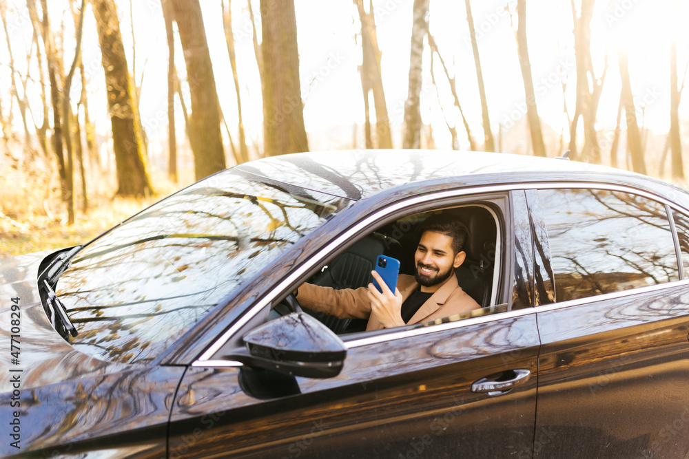 Driver taking photo with camera smartphone driving in car. Happy man ...