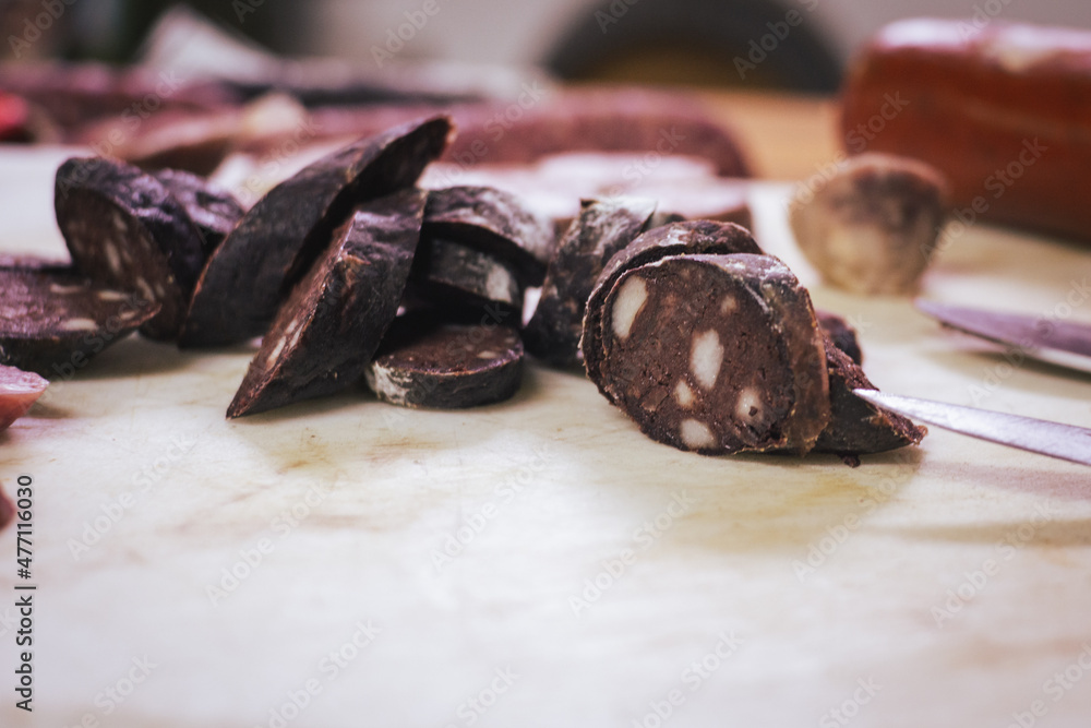 Tapa de morcilla cortada sobre una tabla y de fondo más embutidos ...