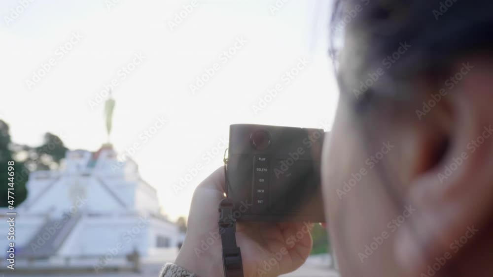 Close up back view of Asian woman standing and using camera to take a ...