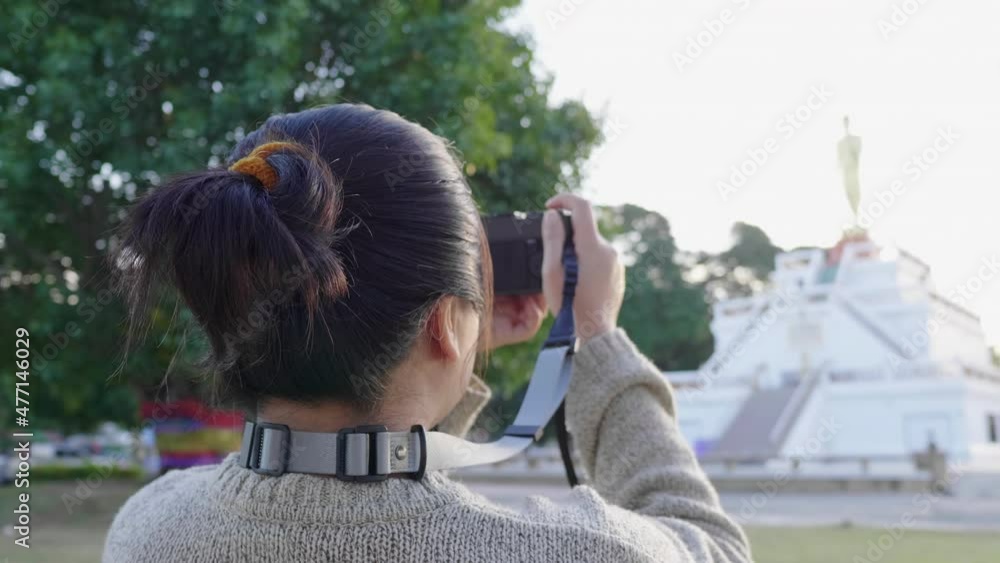 Back view of Asian woman standing and using camera to take a picture at ...