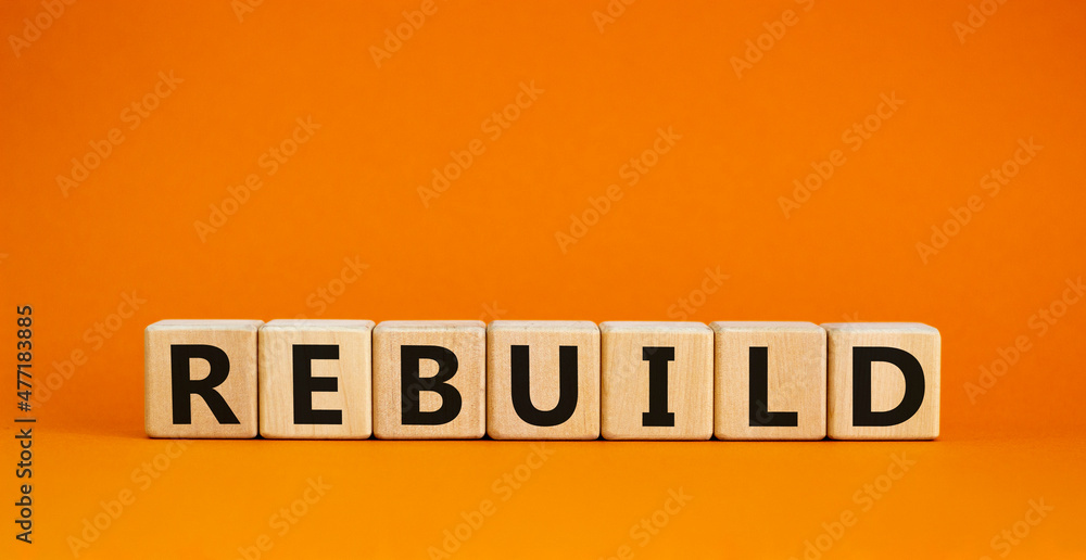 Rebuild and build symbol. The concept word Rebuild on wooden cubes ...