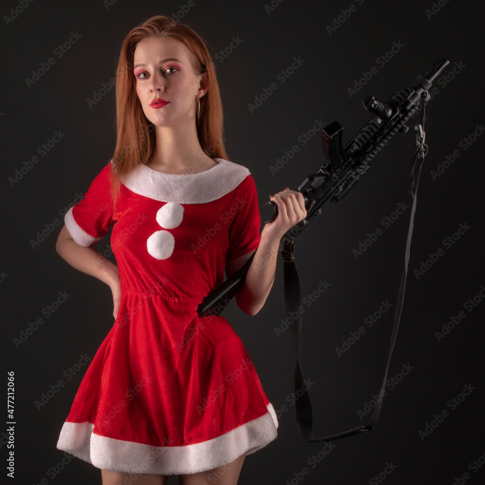 Dangerous bad Santa woman holding gun with evil smile looking at camera ...