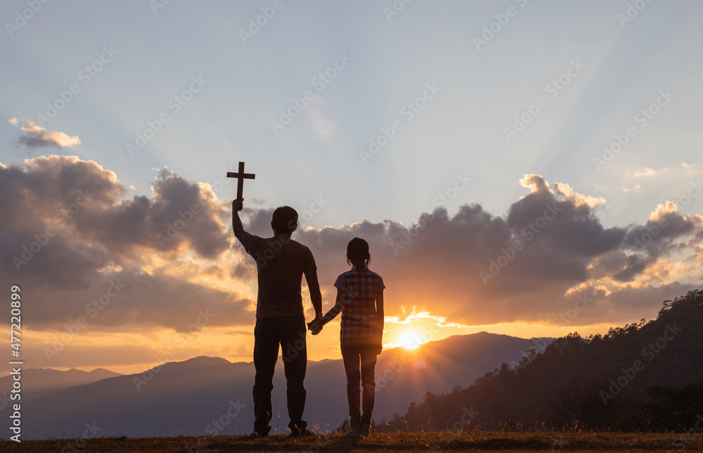 Silhouette Christian father holding Christian cross teaching his ...