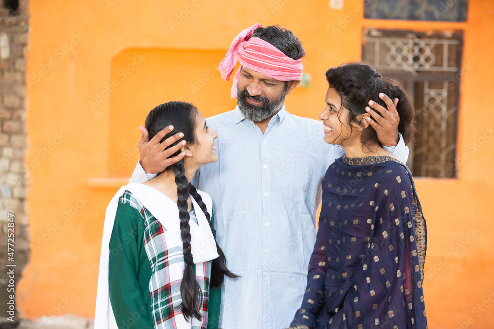 Portrait of happy traditional Indian father with his two young ...