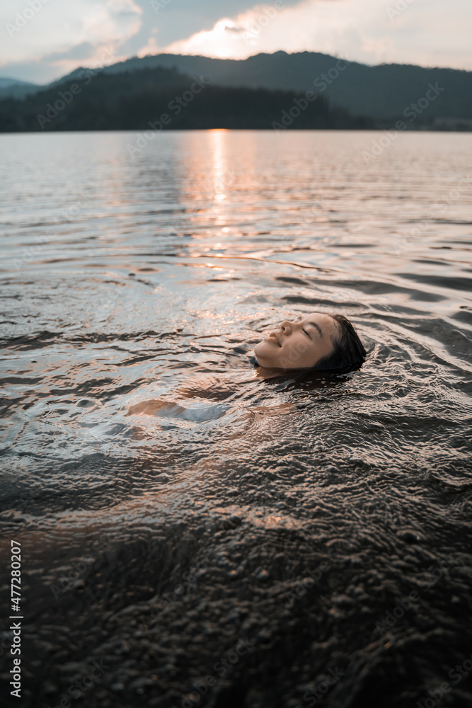 asian woman relaxing in lake water floating on water surface. woman ...