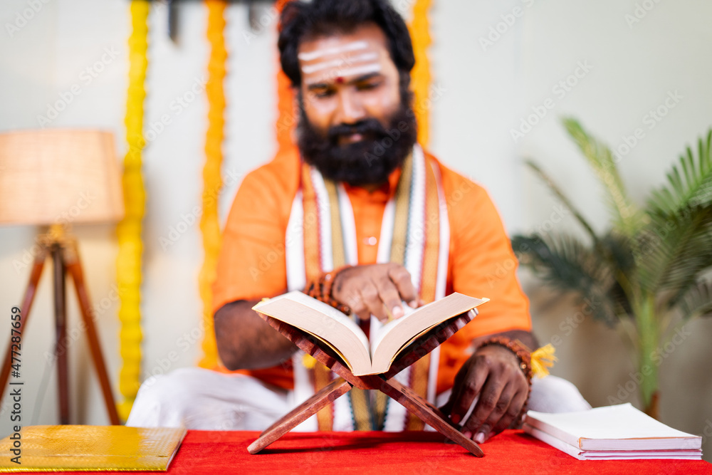 Holy saint preaching by reading holy vedas or puranas to devotees at ...