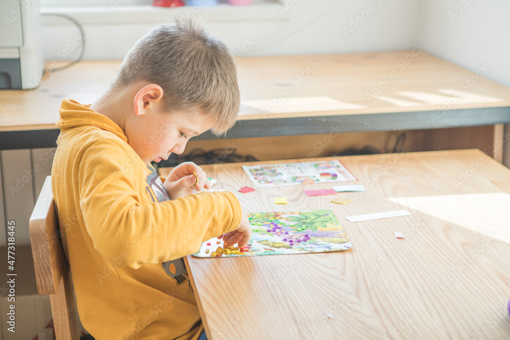 Little boy being creative making homemade do it yourself dinosaur ...