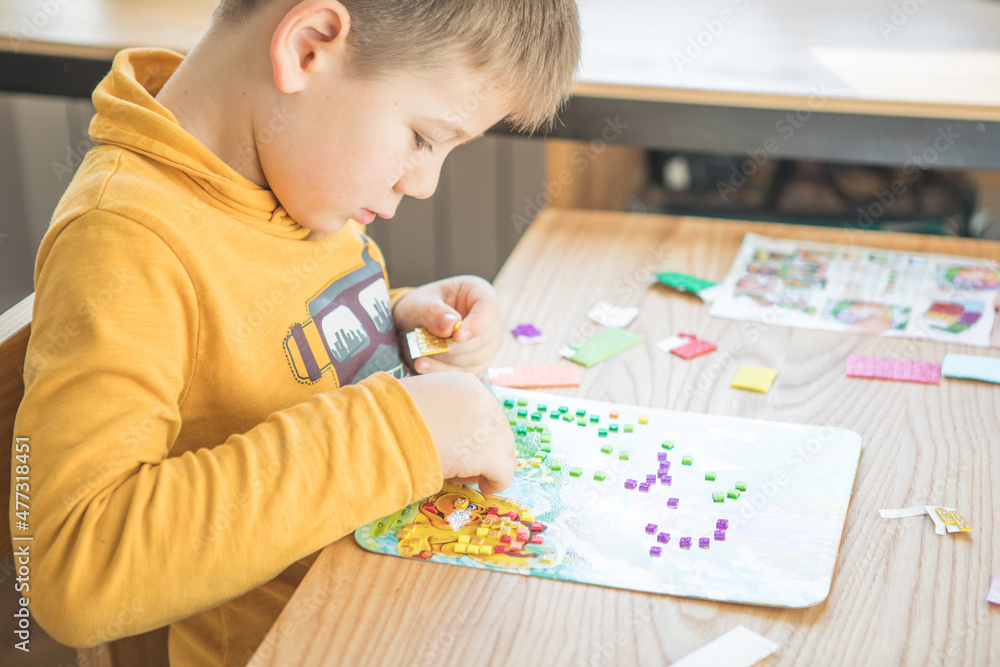Little boy being creative making homemade do it yourself dinosaur ...