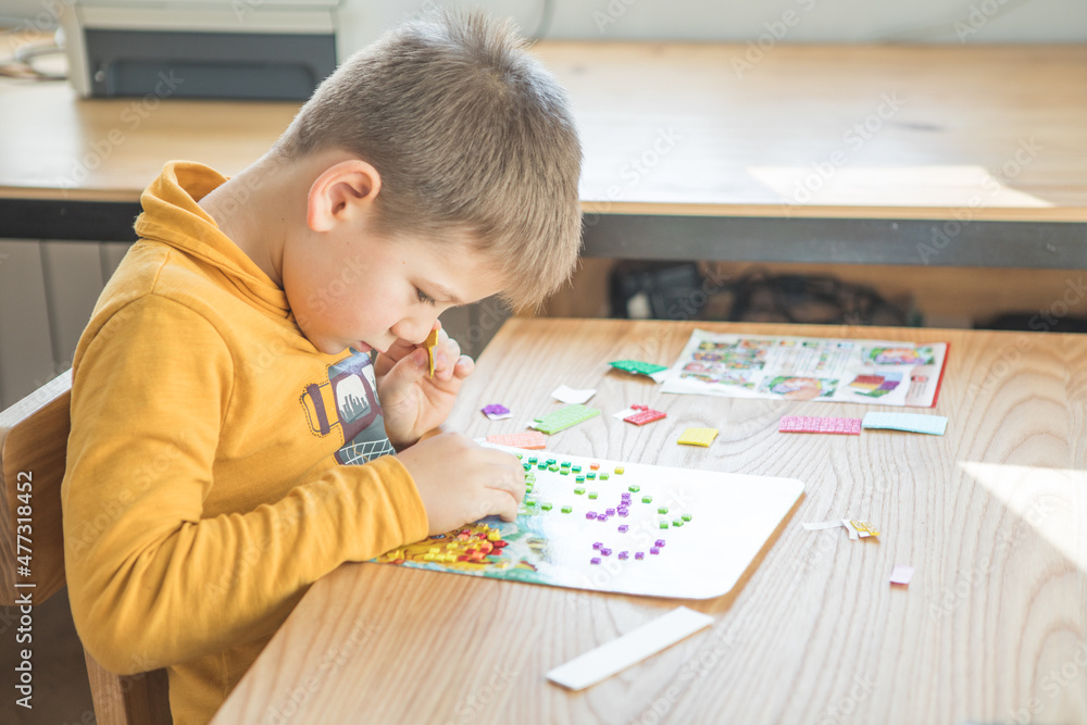 Little boy being creative making homemade do it yourself dinosaur ...