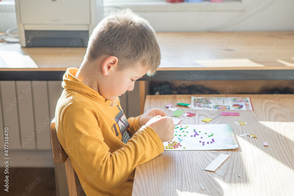 Little boy being creative making homemade do it yourself dinosaur ...