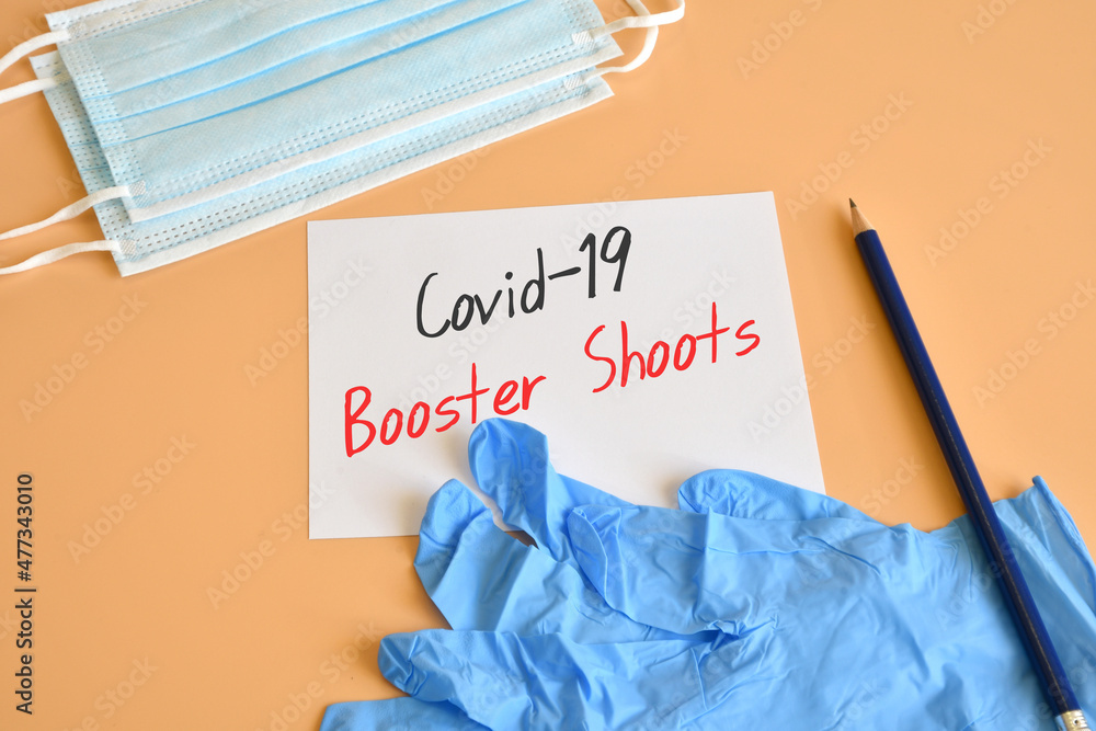 Paper with text 'Covid-19 Booster Shoots' with protective masks and ...