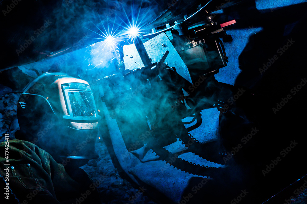 Welder performs welding work automatic welding system. Stainless steel ...