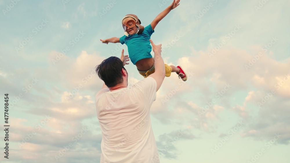Foto de Dad throws his happy son into blue sky, child is pilot, dreams ...