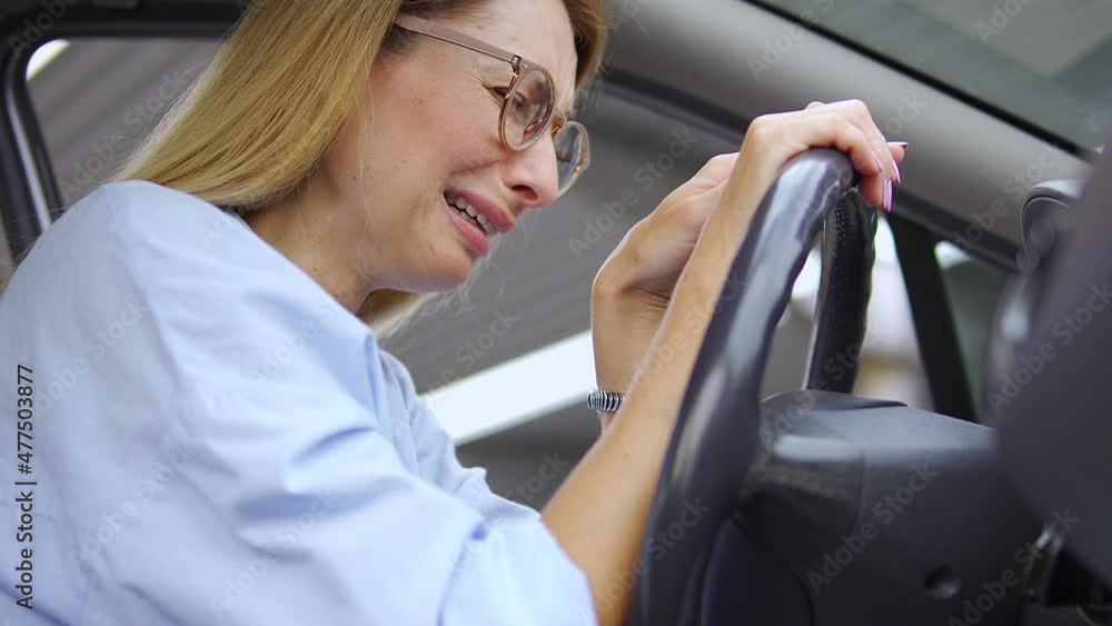 Upset frustrated blond woman crying sitting on driver seat in car ...