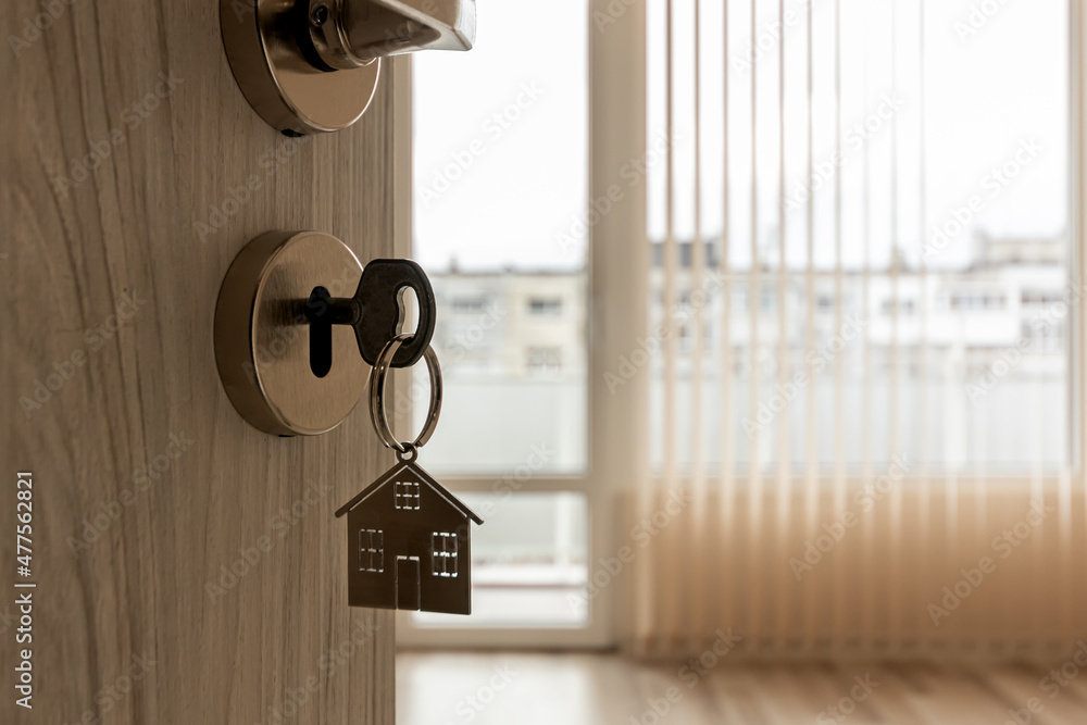 Foto de Open door to a new home with key and home shaped keychain ...