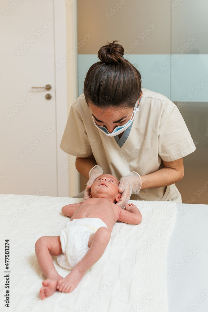 Female physiotherapist doing a positional plagiocephaly correction on a ...
