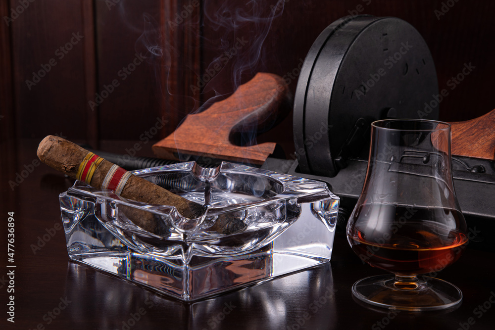 Vintage Thompson submachine gun on a dark brown table with a cigar and ...