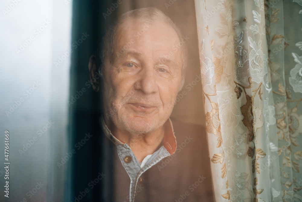 Calm pensive elderly man behind window Stock Photo | Adobe Stock
