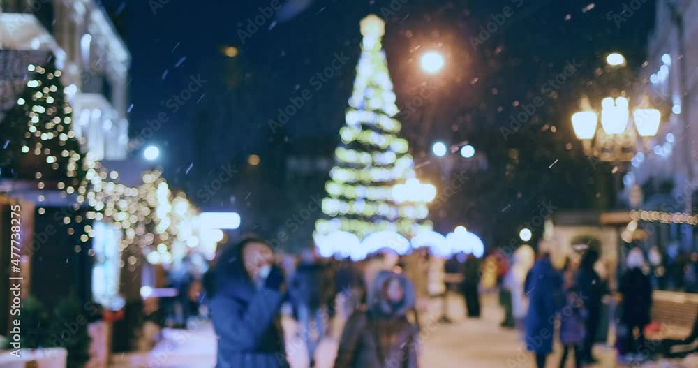 defocused crowded christmas fair at the city square in beautiful snowy ...