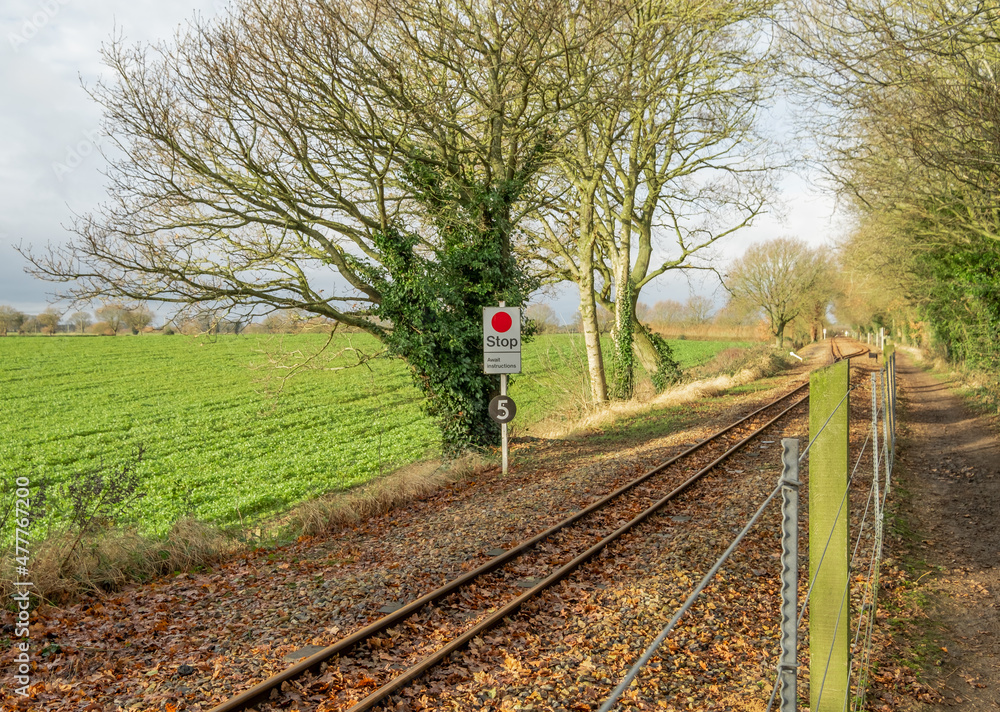 A train stop sign on the side of the railway tracks of the Bure Valley ...