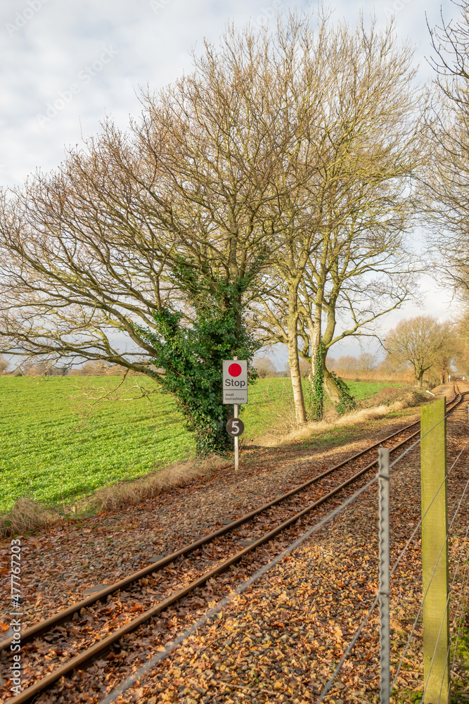 A train stop sign on the side of the railway tracks of the Bure Valley ...