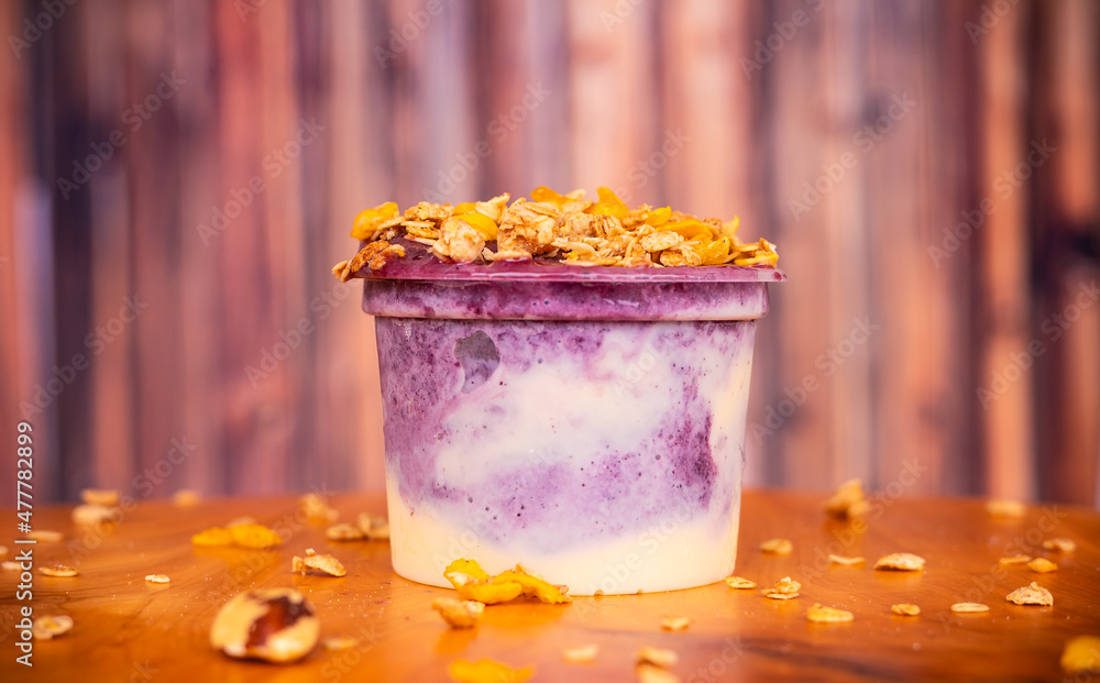 Açaí. Um açaí congelado com leite condensado e granola em um pote de ...