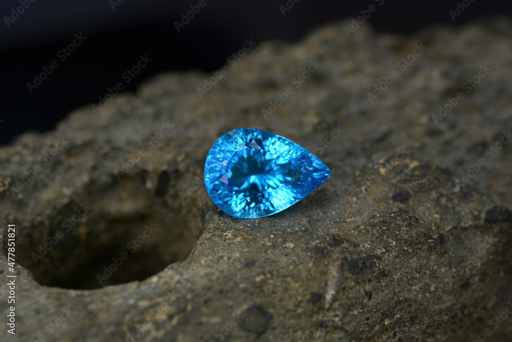 Millennium concave cut swiss blue topaz gemstone placed on an ancient ...